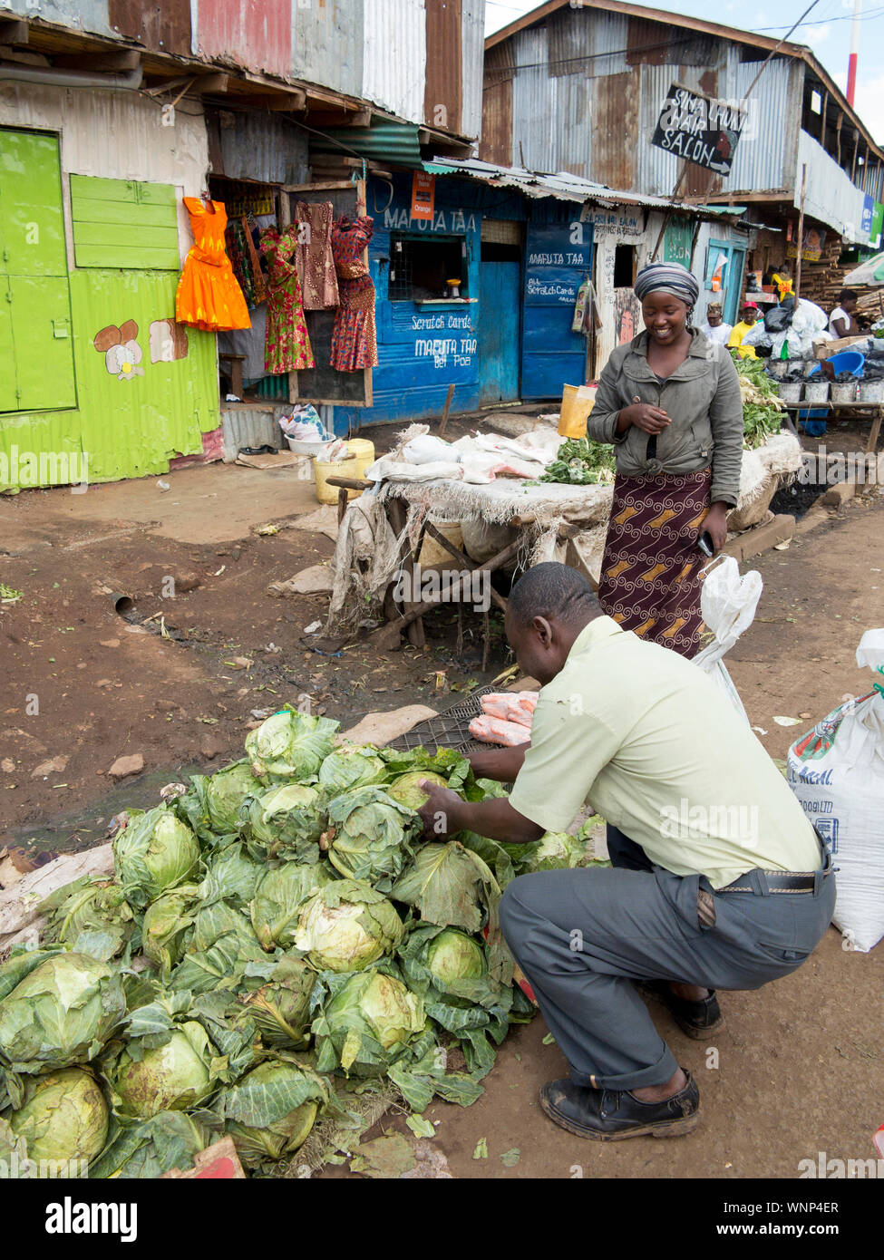 KIBERA, KENYA-NOVEMBER 6, 2015: Unidentified man buys cabbage from a ...