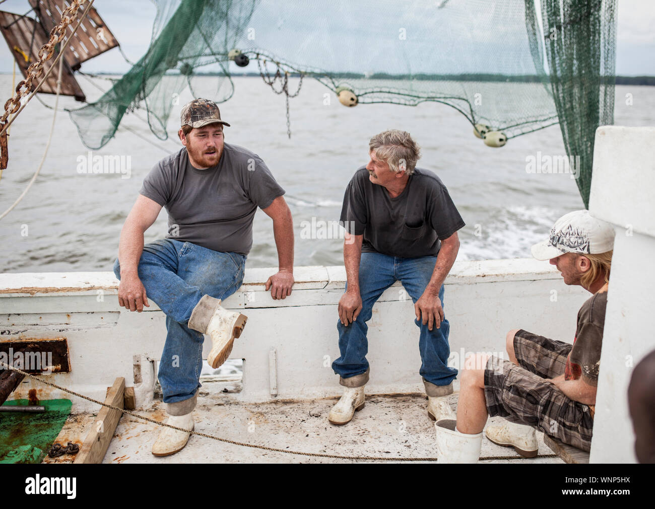 Environmental portrait of commercial fishermen on the deck of a ship ...