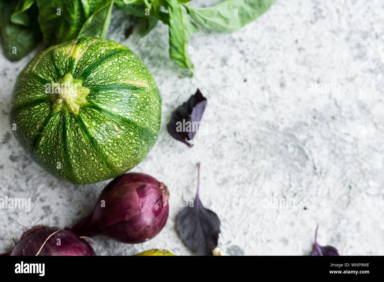 Flat-lay of green and purple raw vegetables over grey background, food ...