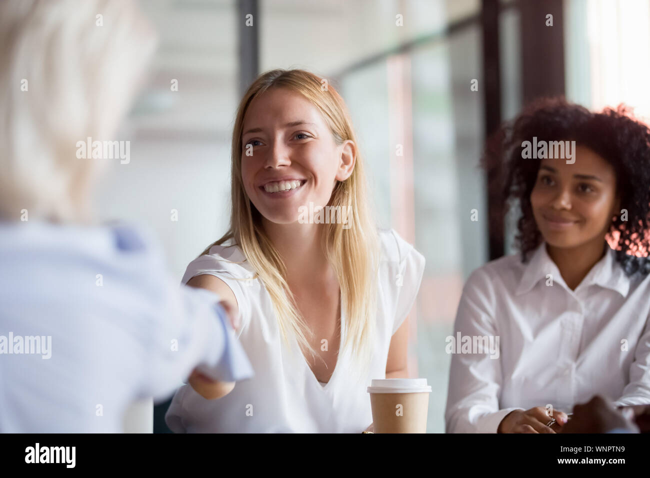 Smiling female employee handshake colleague at company meeting Stock Photo - Alamy