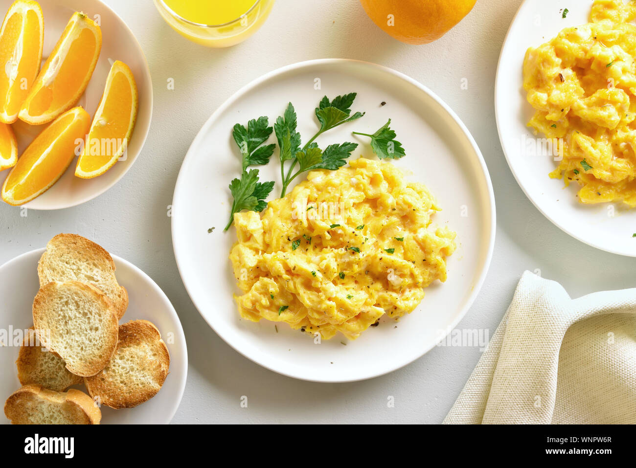 Scrambled eggs and orange juice over white stone background. Top view ...
