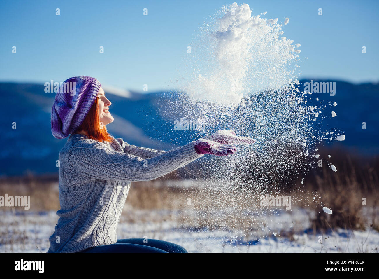 Winter portrait of young beautiful brunette woman wearing knitted snood ...