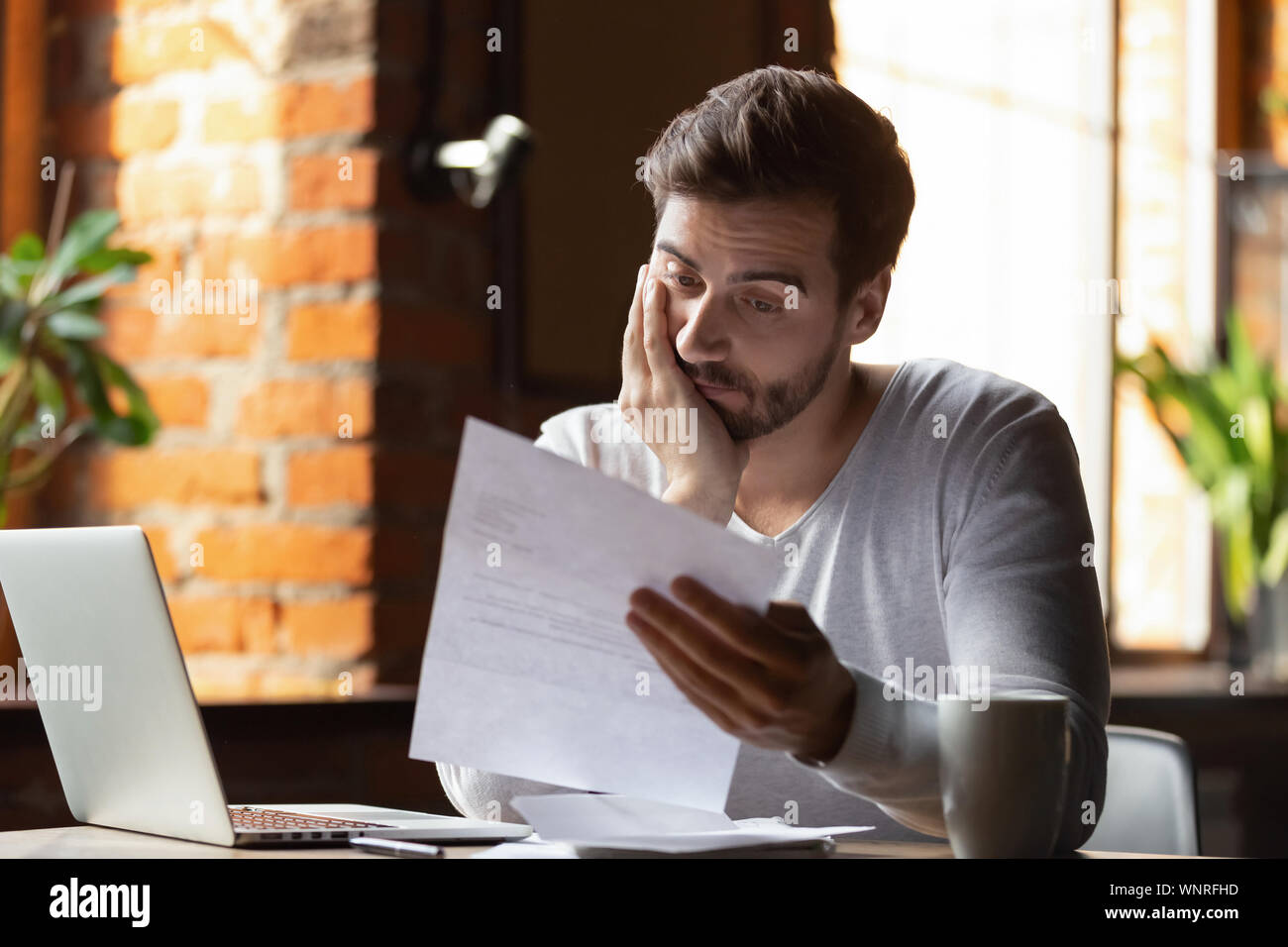 Confused frustrated man reading letter in cafe, receiving bad news ...