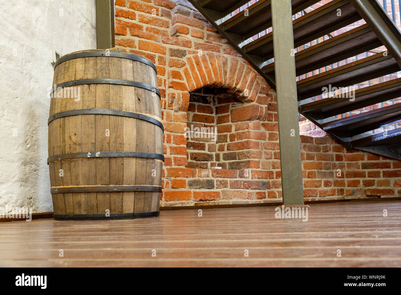 Old wooden barrel against the white wall. Exhibit in the museum. Light ...