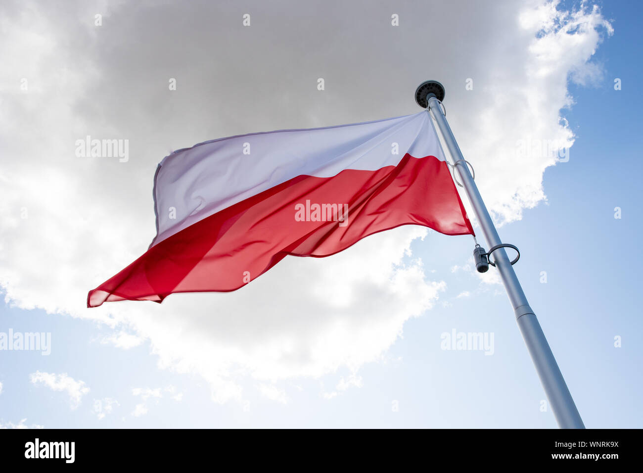 Polish flag on a background of the cloudy sky. National symbol of ...
