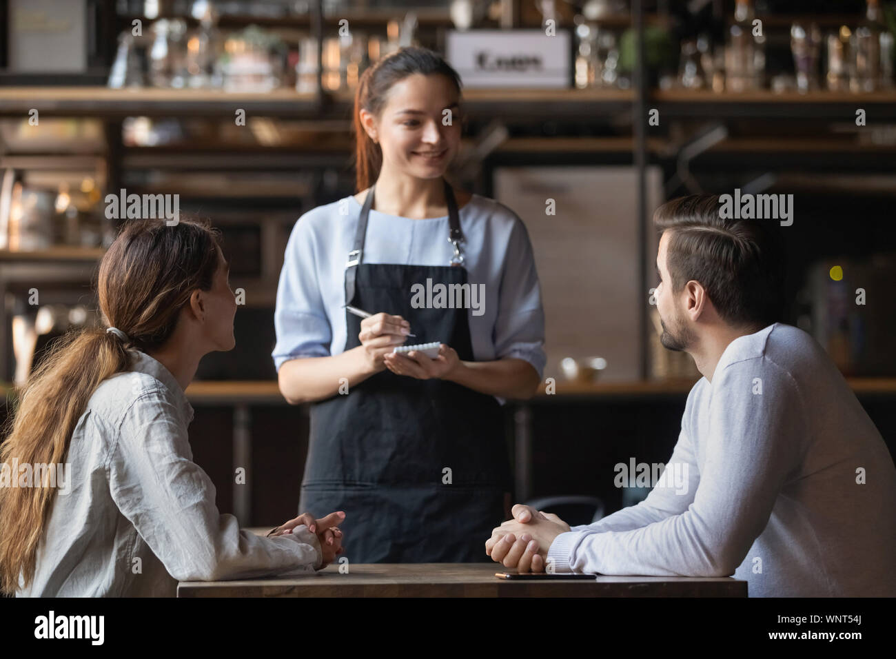 Couple making order in cafe, smiling waitress writing in notepad Stock ...