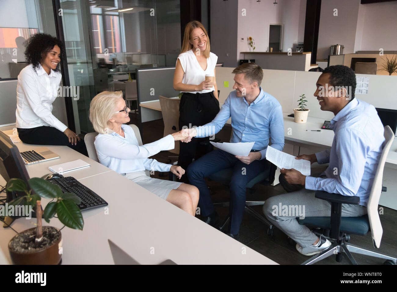 Smiling employees handshake getting acquainted at informal meeting ...