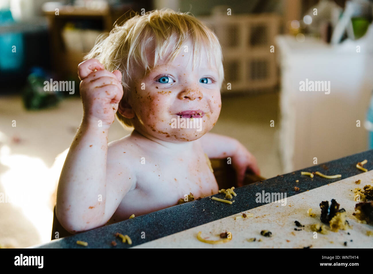 Toddler at table with huge dinner mess in front of him and on face ...