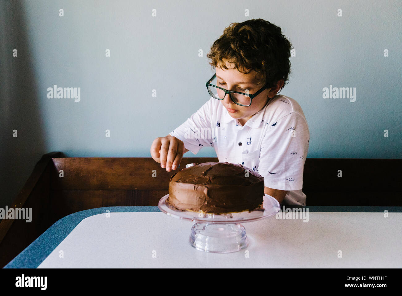 Tween boy frosting his birthday cake with chocolate frosting.o Stock ...