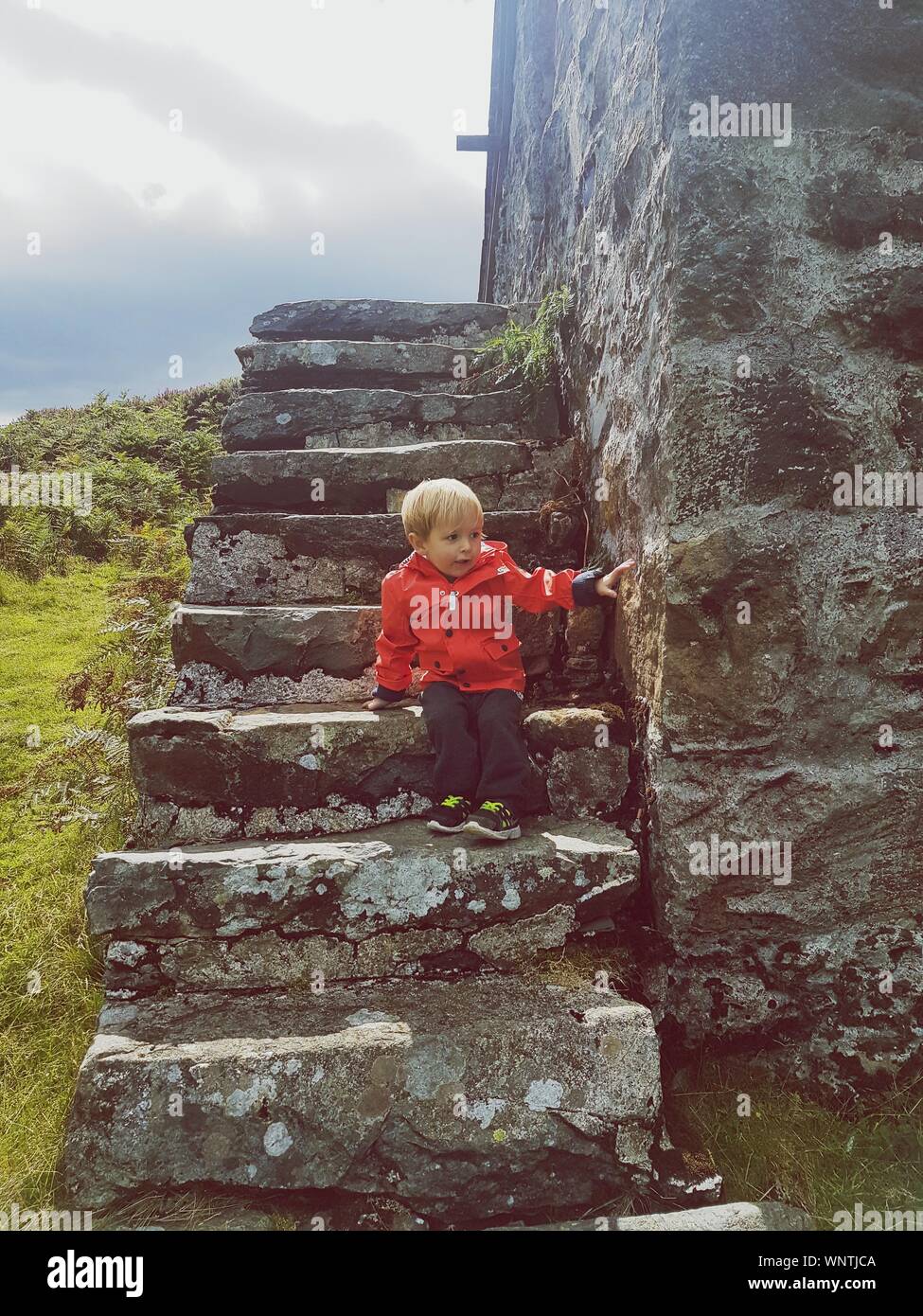 Boy sitting on stone hi-res stock photography and images - Alamy