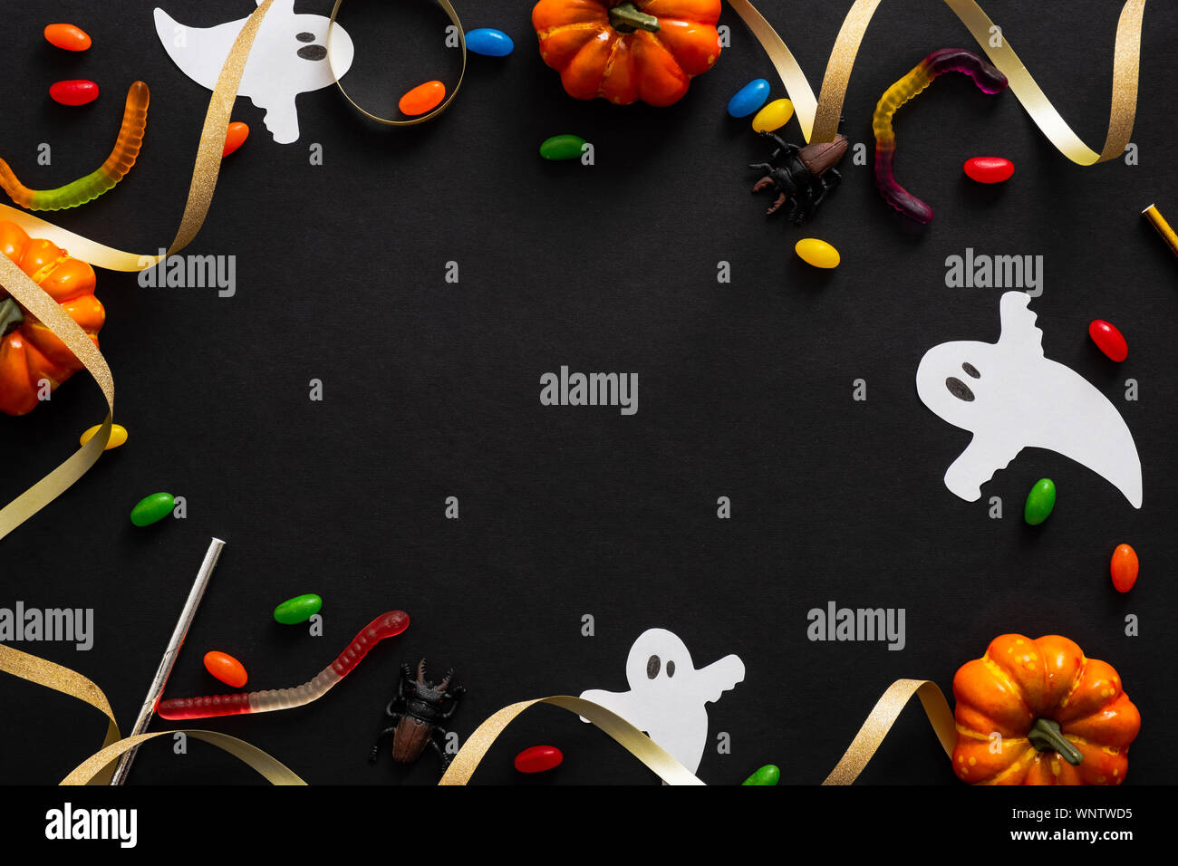 Halloween frame with pumpkins, ghosts, candy, ribbon on black ...