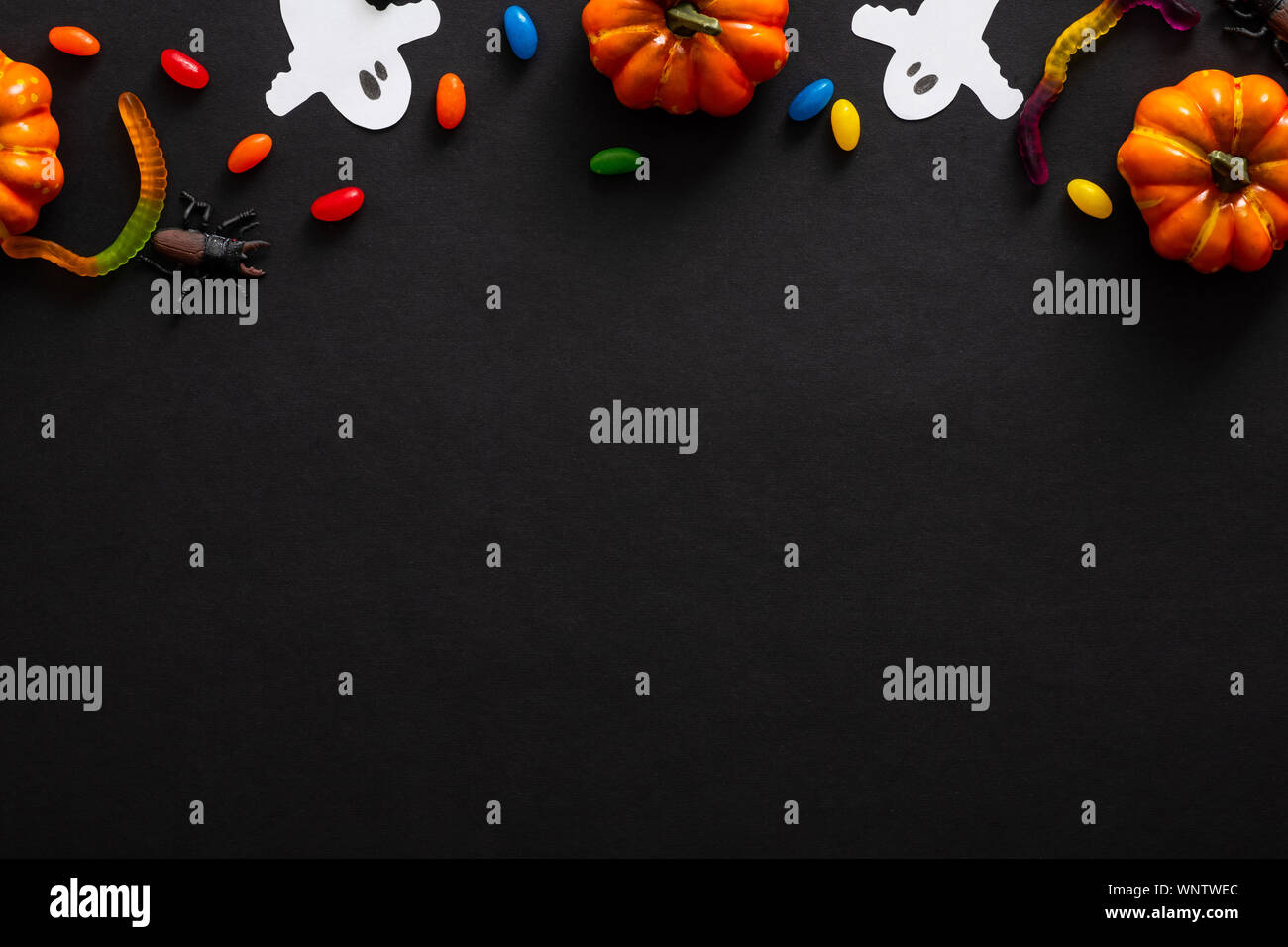 Halloween composition with pumpkins, ghosts, candy on black background ...