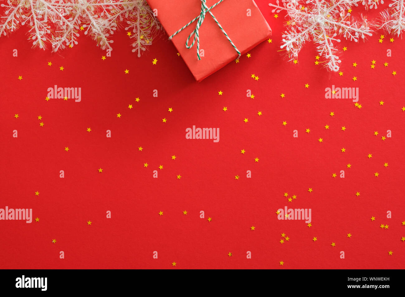 Christmas gift box present on red background with white snowflakes and ...