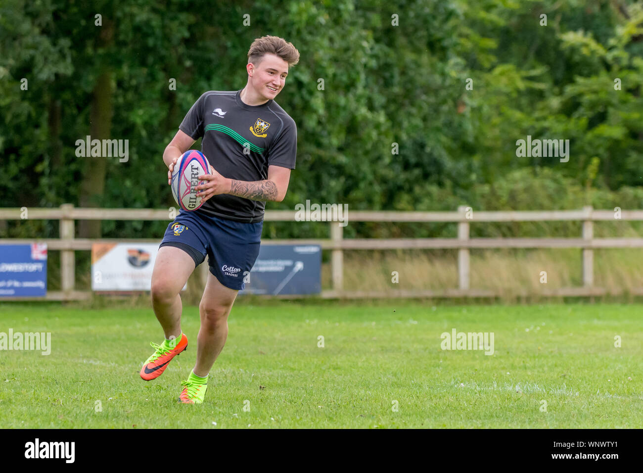 Amateur touch rugby player (male 20 y) running with rugby ball in hands ...