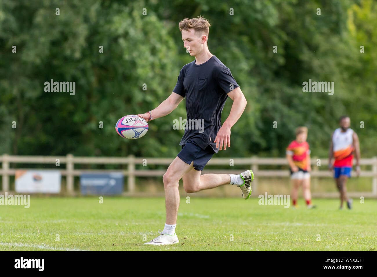 Young male rugby player (age 150-25 years) running with rugby ball in ...