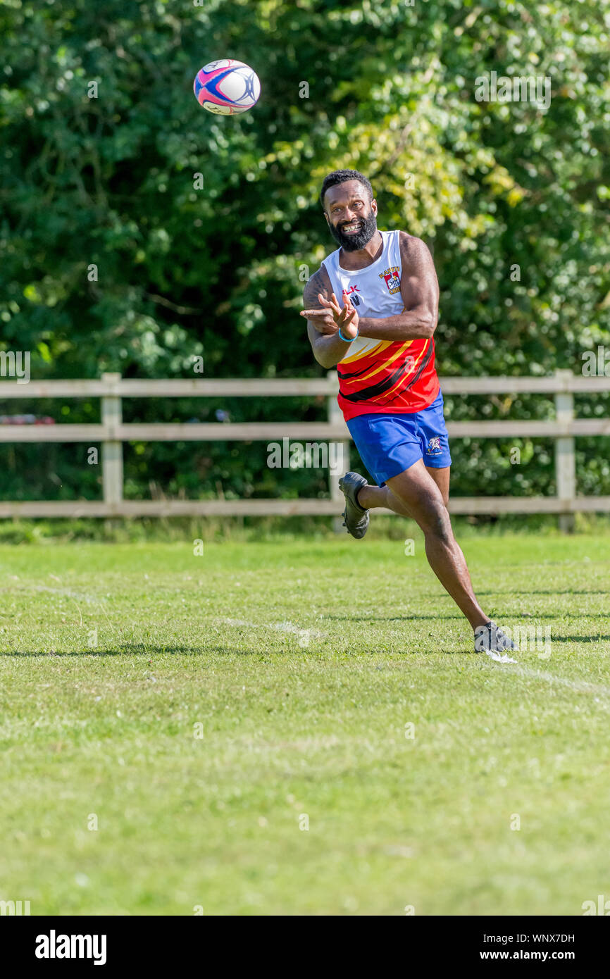 Amateur touch rugby payer (Fijian male, 40-50 y) running with one foot ...
