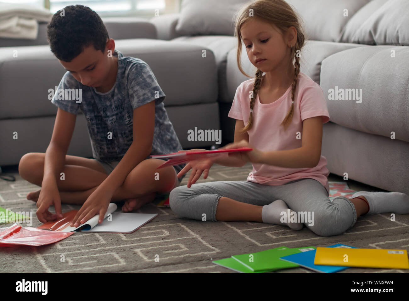 Diligent children preparing notebooks for new school year Stock Photo ...