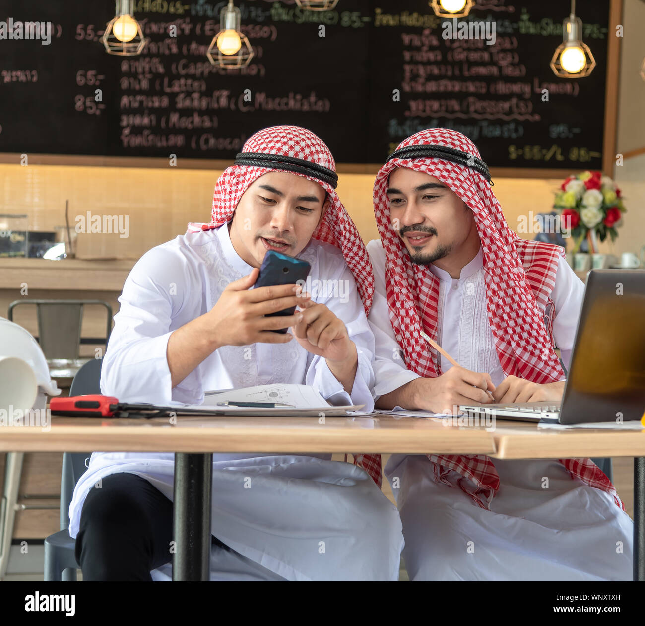 Two young businessman Arabian entrepreneur talking on mobile phone cell ...
