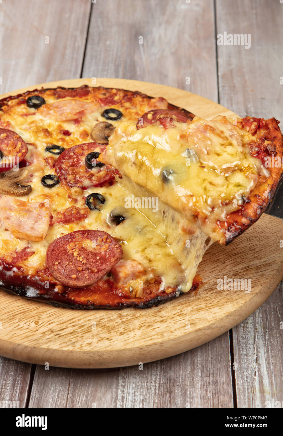 Pizza on an old wooden studio background Stock Photo - Alamy
