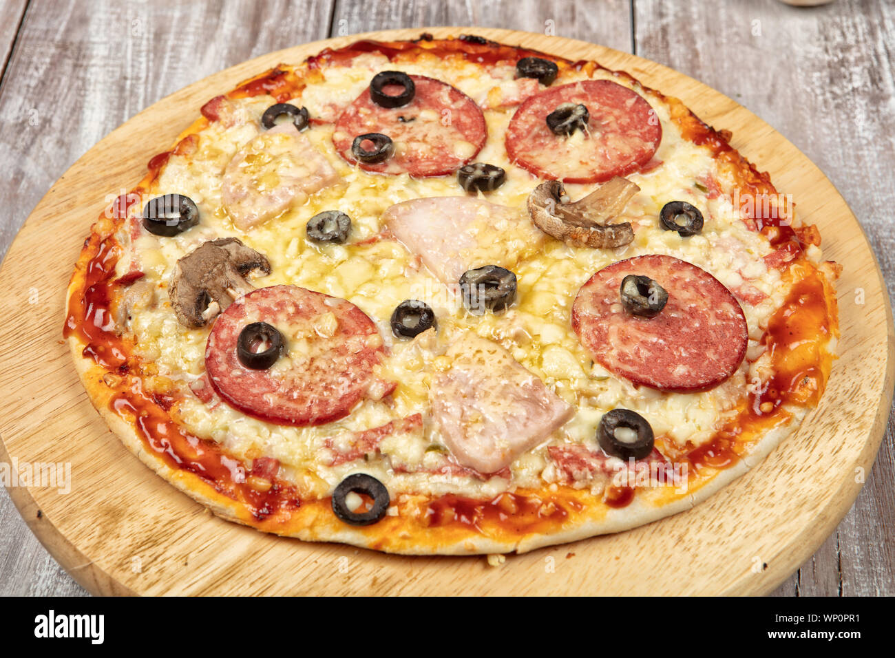 Pizza on an old wooden studio background Stock Photo - Alamy