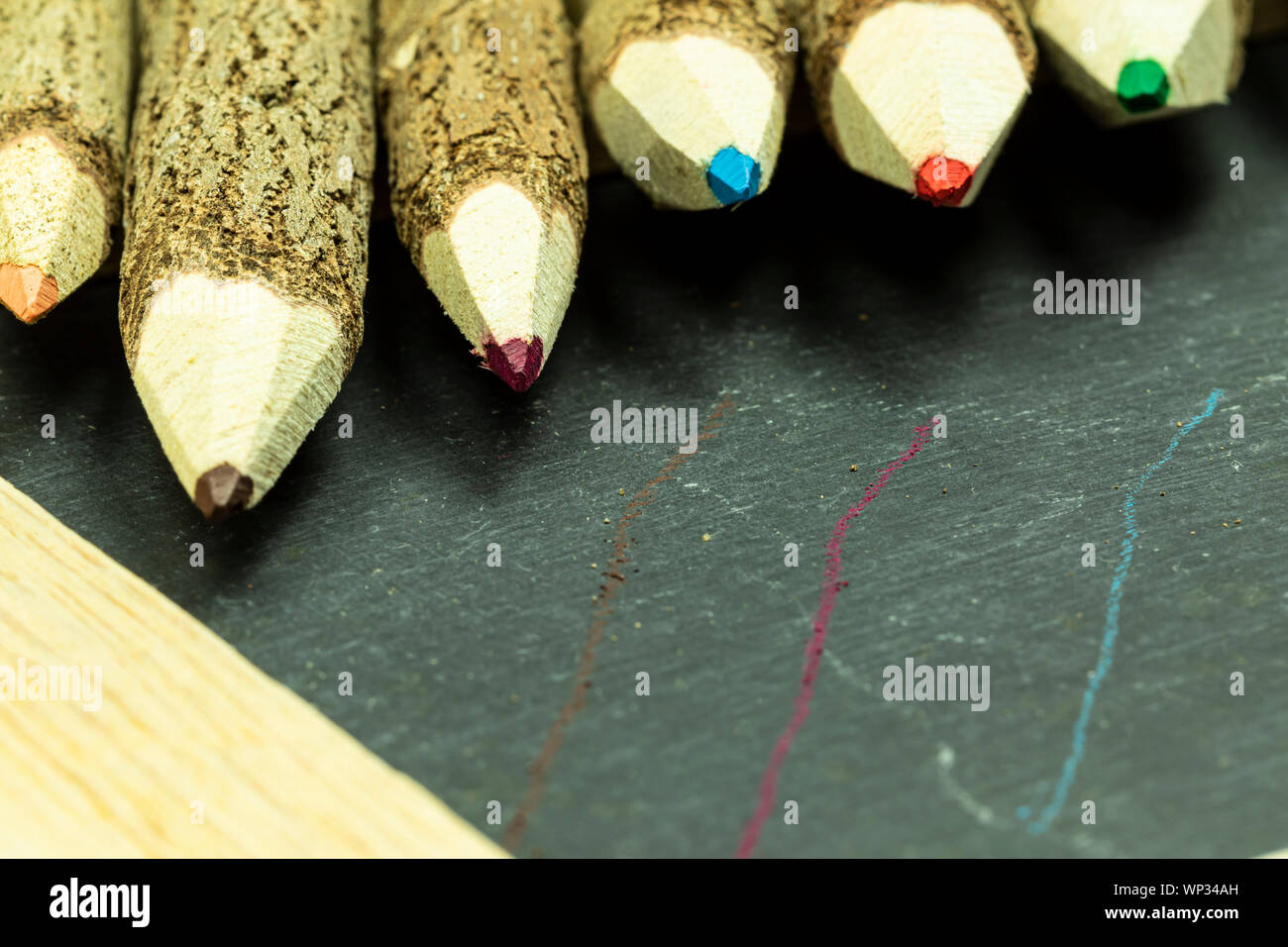 Colored pencils made from branches of trees on slate background Stock ...