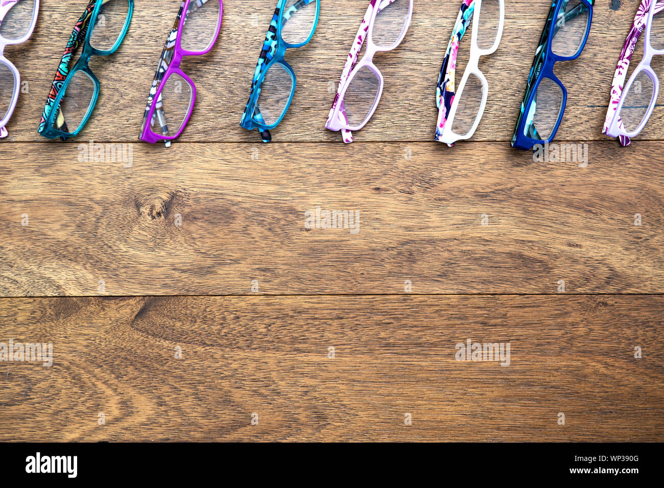 multiple colored eye glasses lined on wooden deck. Eye Health Concept ...