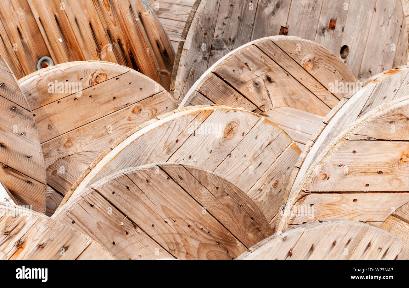 large wooden spools for cables lying empty beside urban construction ...