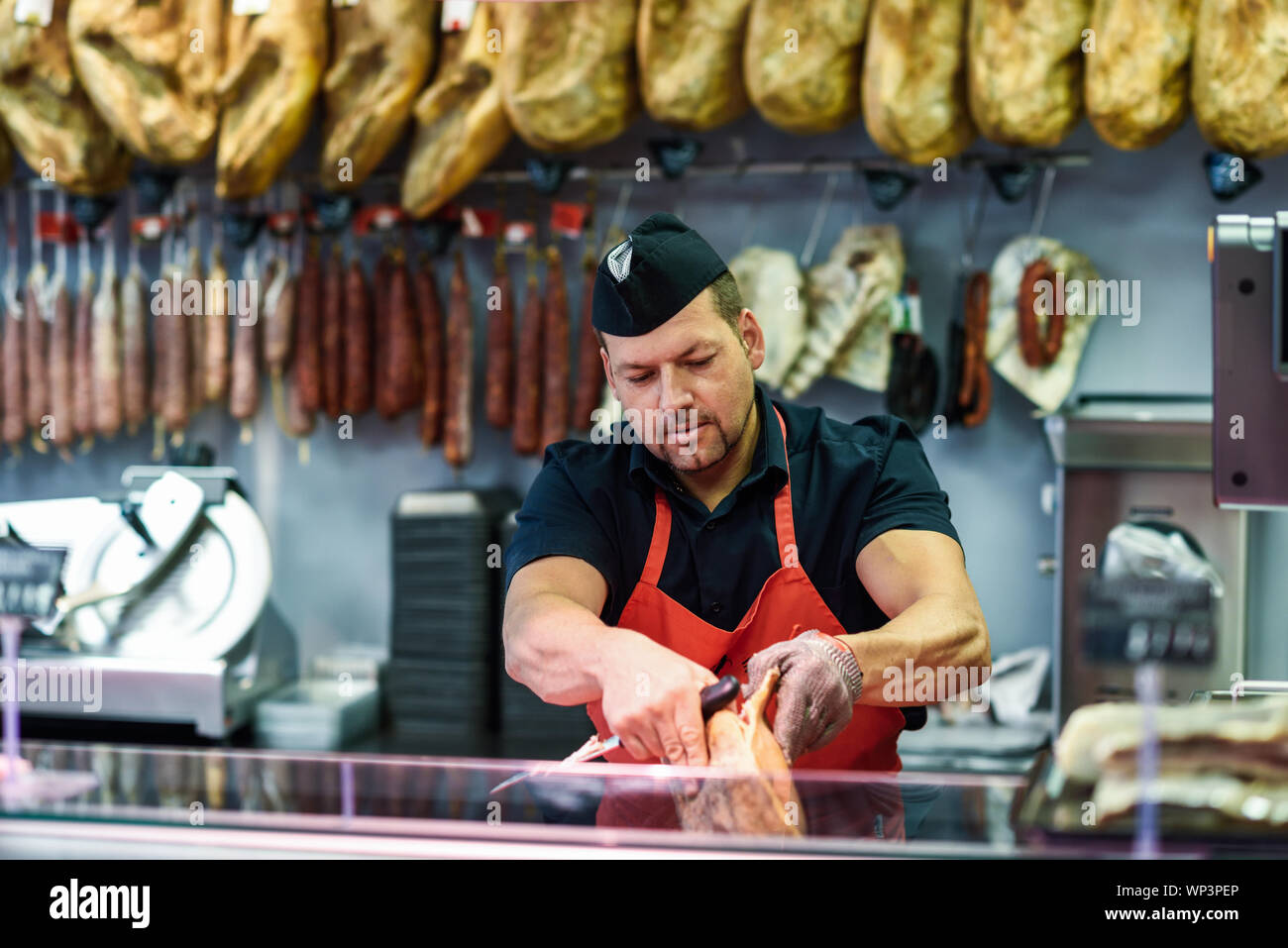 Butcher boning a ham in a modern butcher shop Stock Photo - Alamy