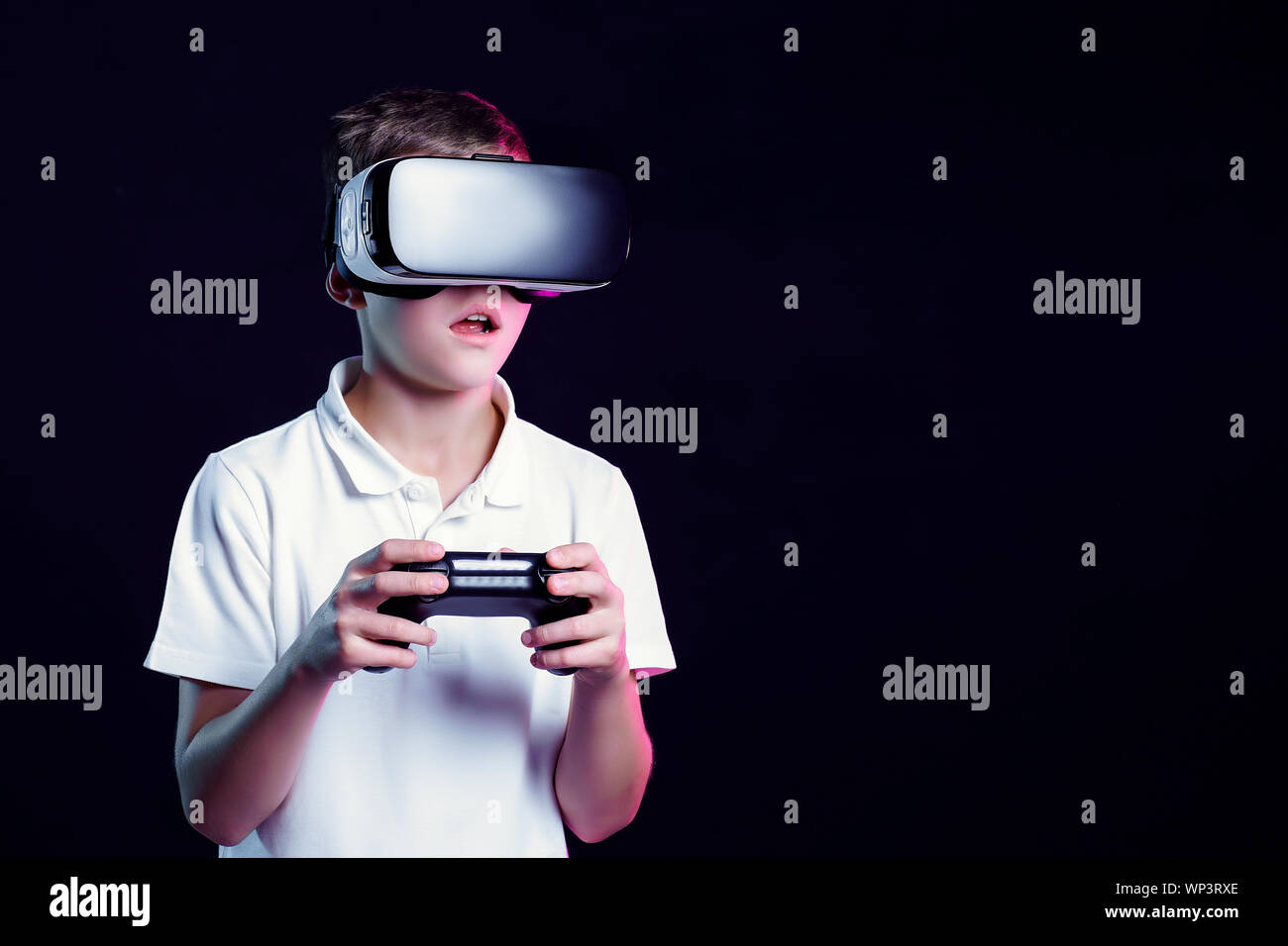 Excited kid in white t-shirt and virtual reality headset standing ...