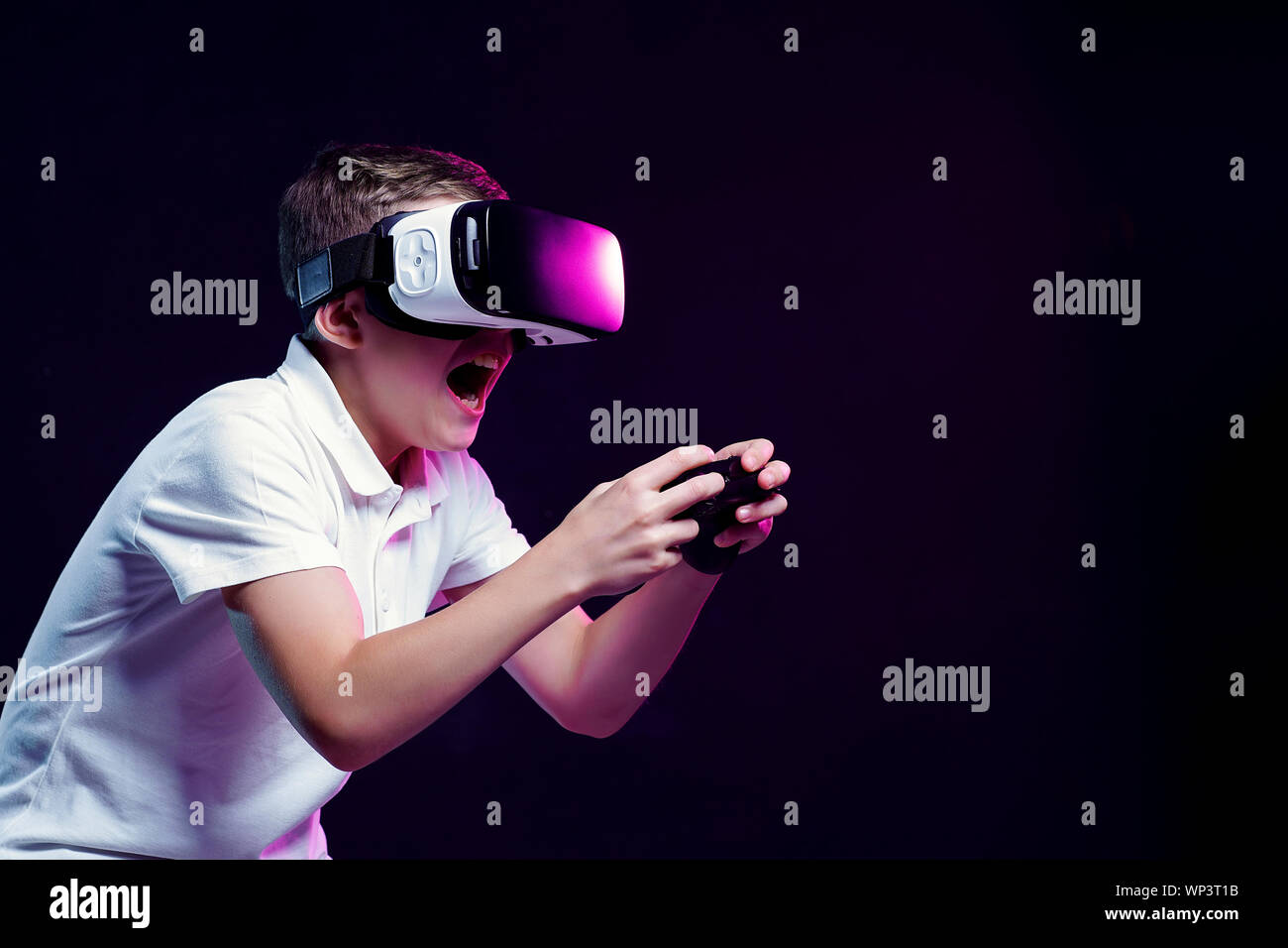 Side view of excited kid in white t-shirt and virtual reality headset ...