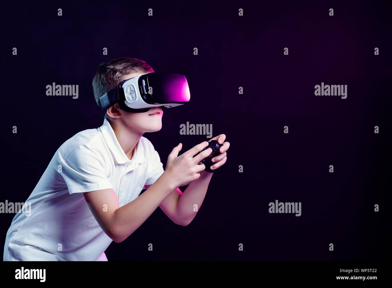 Side view of excited kid in white t-shirt and virtual reality headset ...