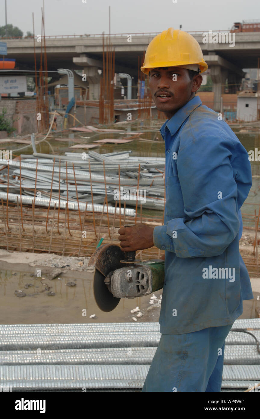 Manual worker working at construction site Stock Photo - Alamy