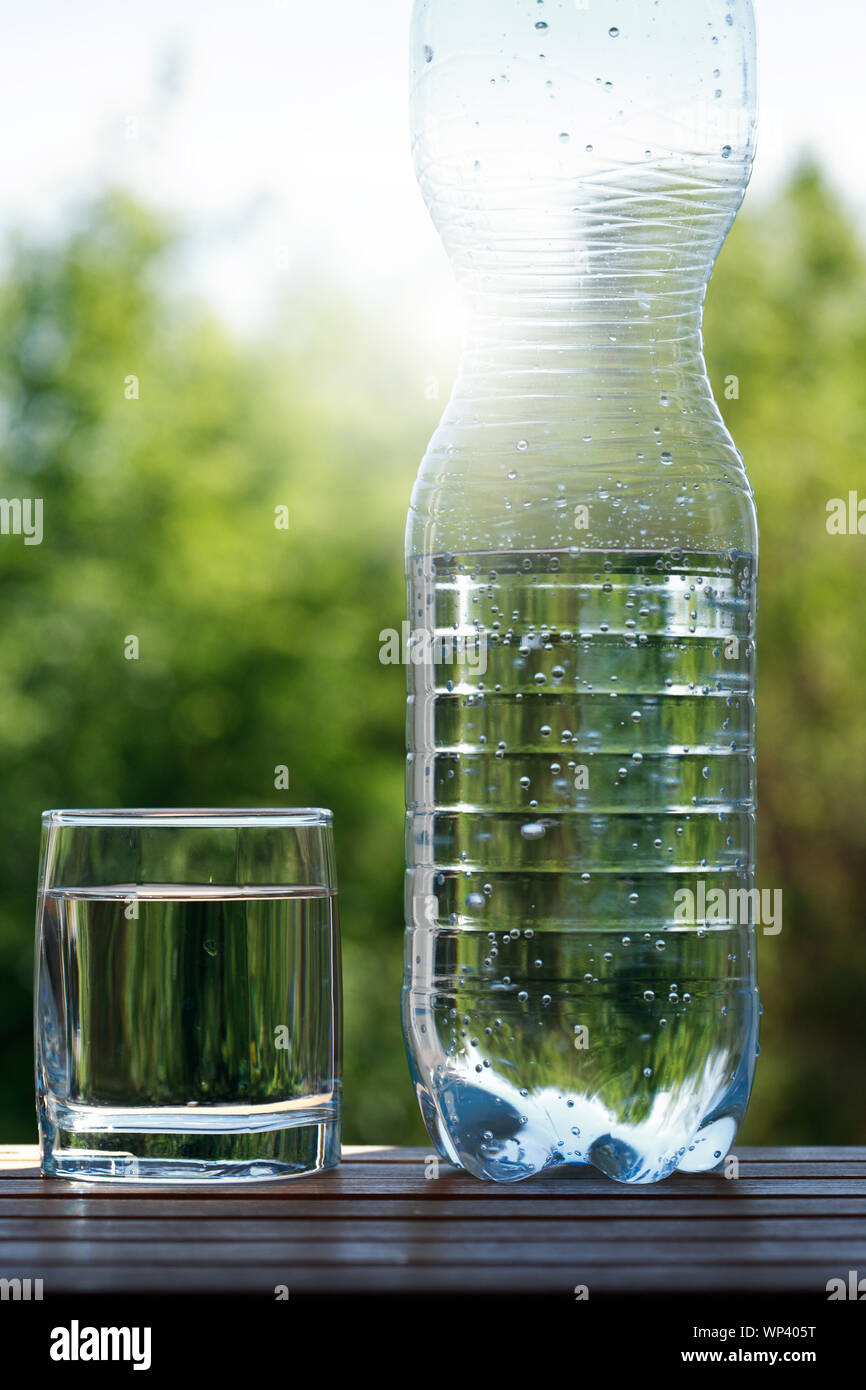 Cold mineral water against nice green nature background Stock Photo - Alamy