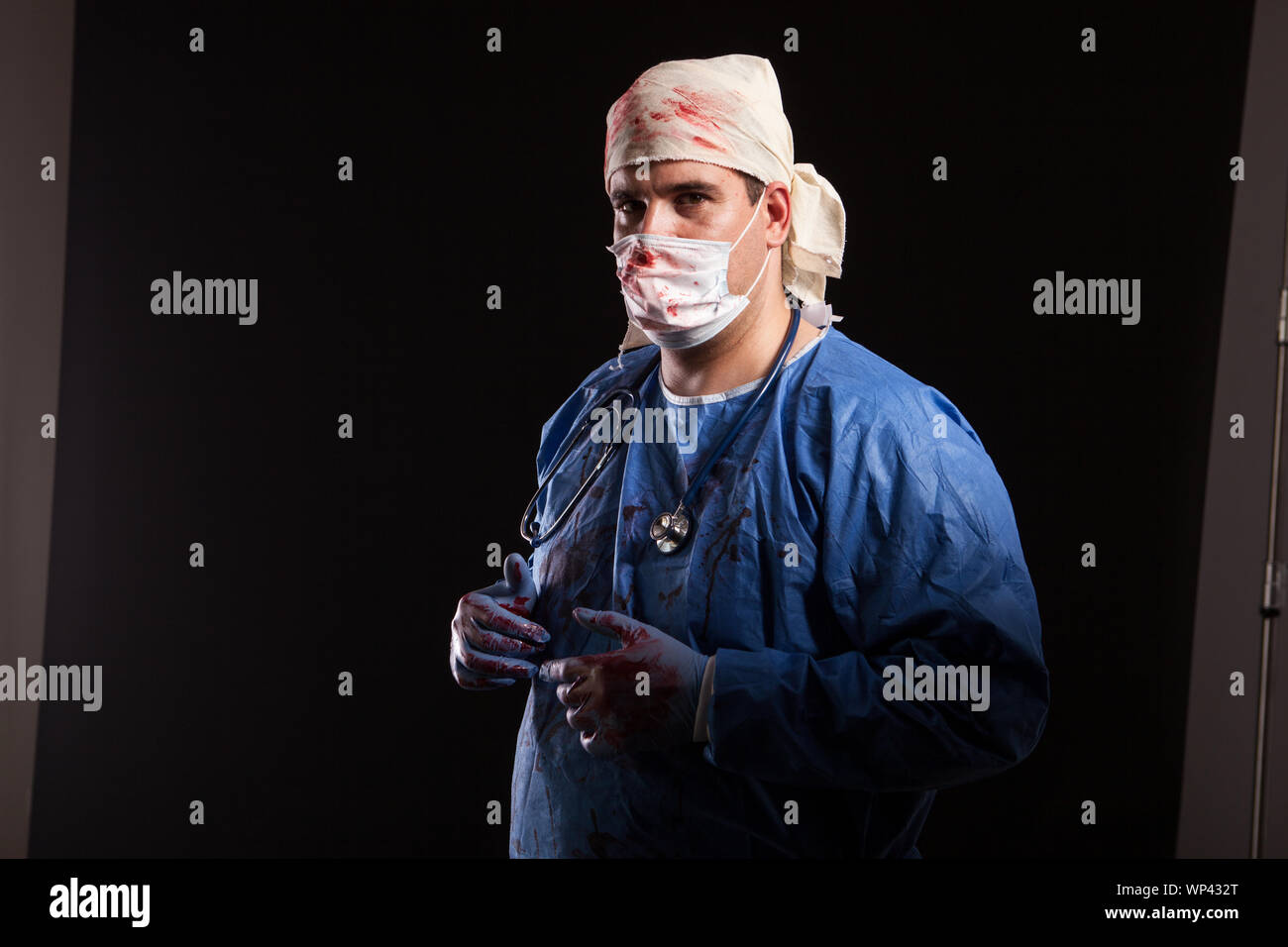 Side view portrait of crazy doctor with blood on his coat looking at ...