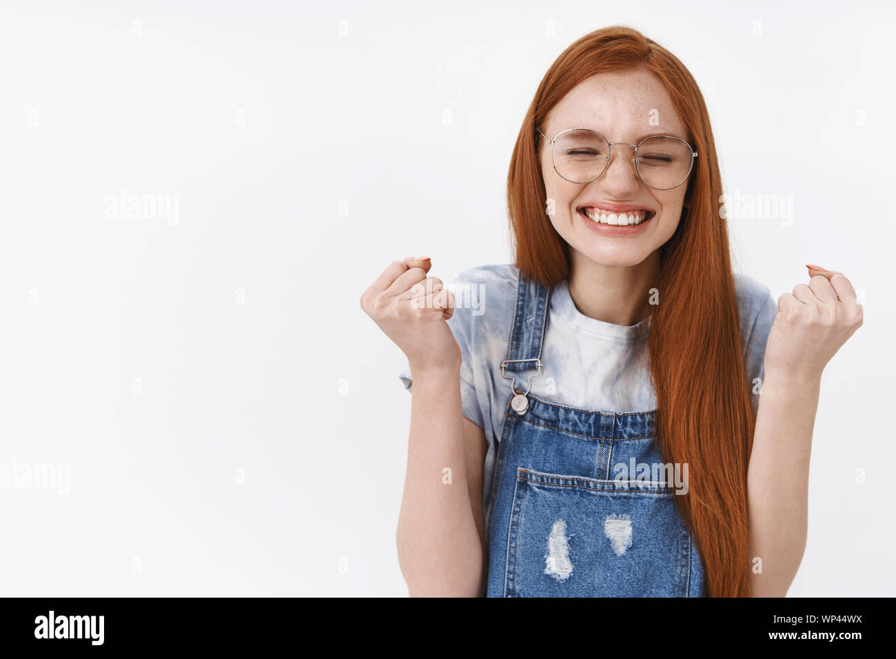 Yes I did it. Cheerful happy triumphing redhead girl close eyes make ...