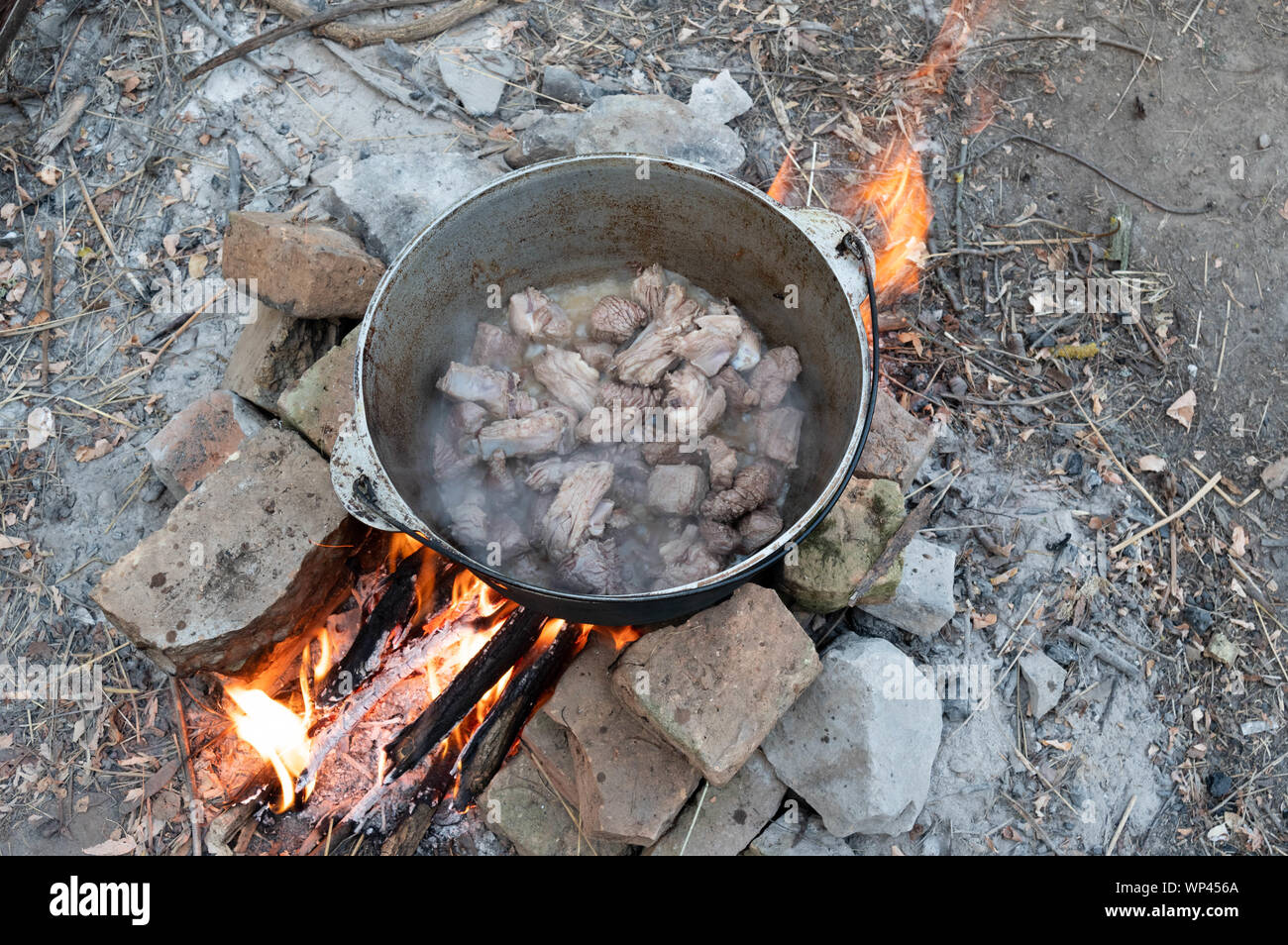 Cooking meat at the stake. Cooking meat in a cauldron Stock Photo - Alamy