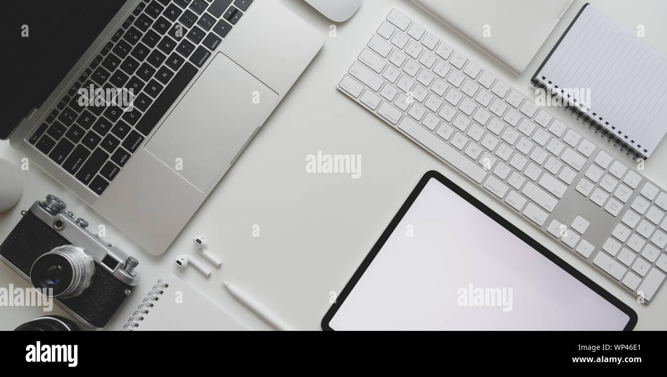 Top view of modern workplace with laptop computer, camera, tablet ...