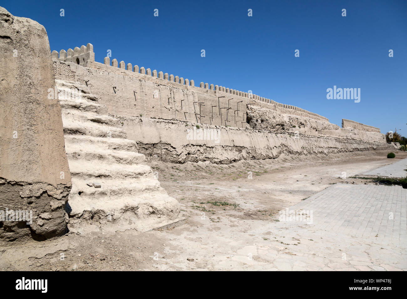 The ancient mud brick walls surrounding the town of Bukhara in ...