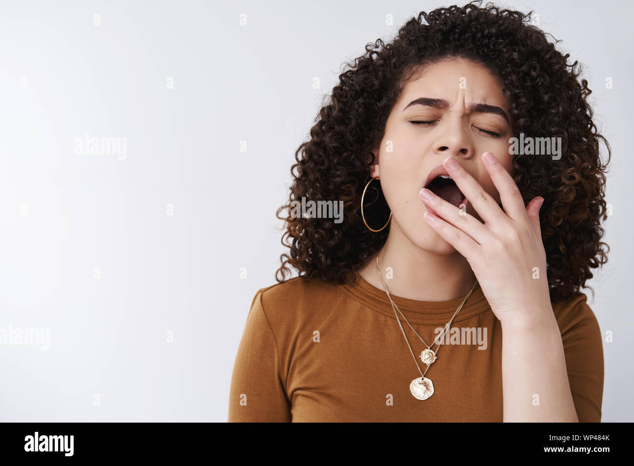 Girl uninterested falling asleep boring talks. Cute 20s curly-haired ...