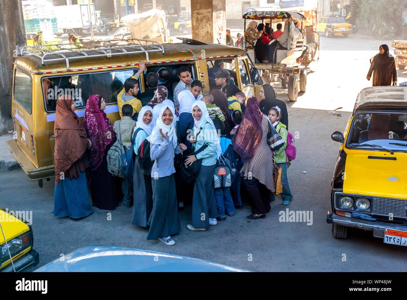 Passengers, including a group of Muslim girls, rush to board a small ...