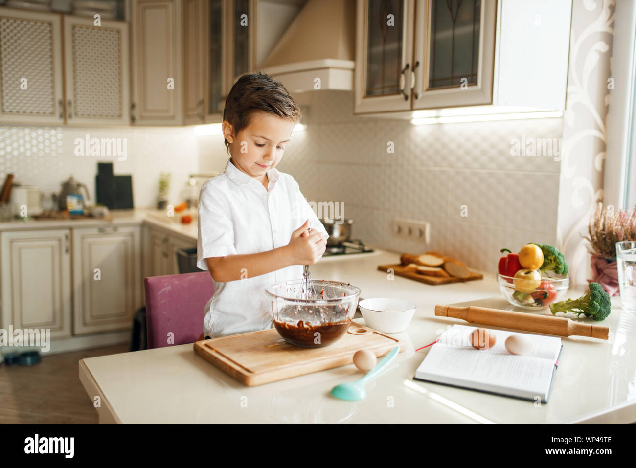 Boy mixing chocolate in kitchen hi-res stock photography and images - Alamy