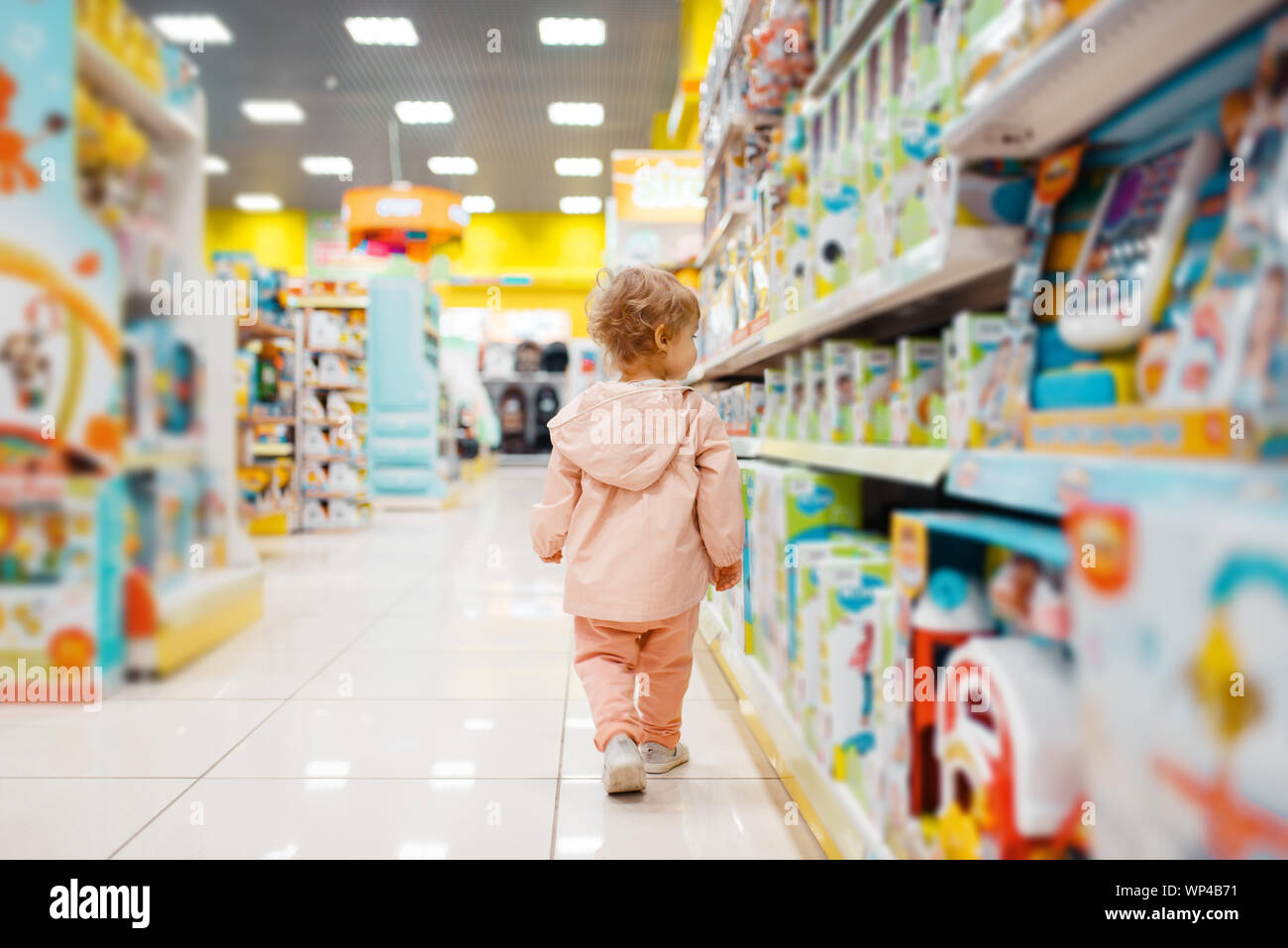 Little girl choosing toys in kids store Stock Photo - Alamy