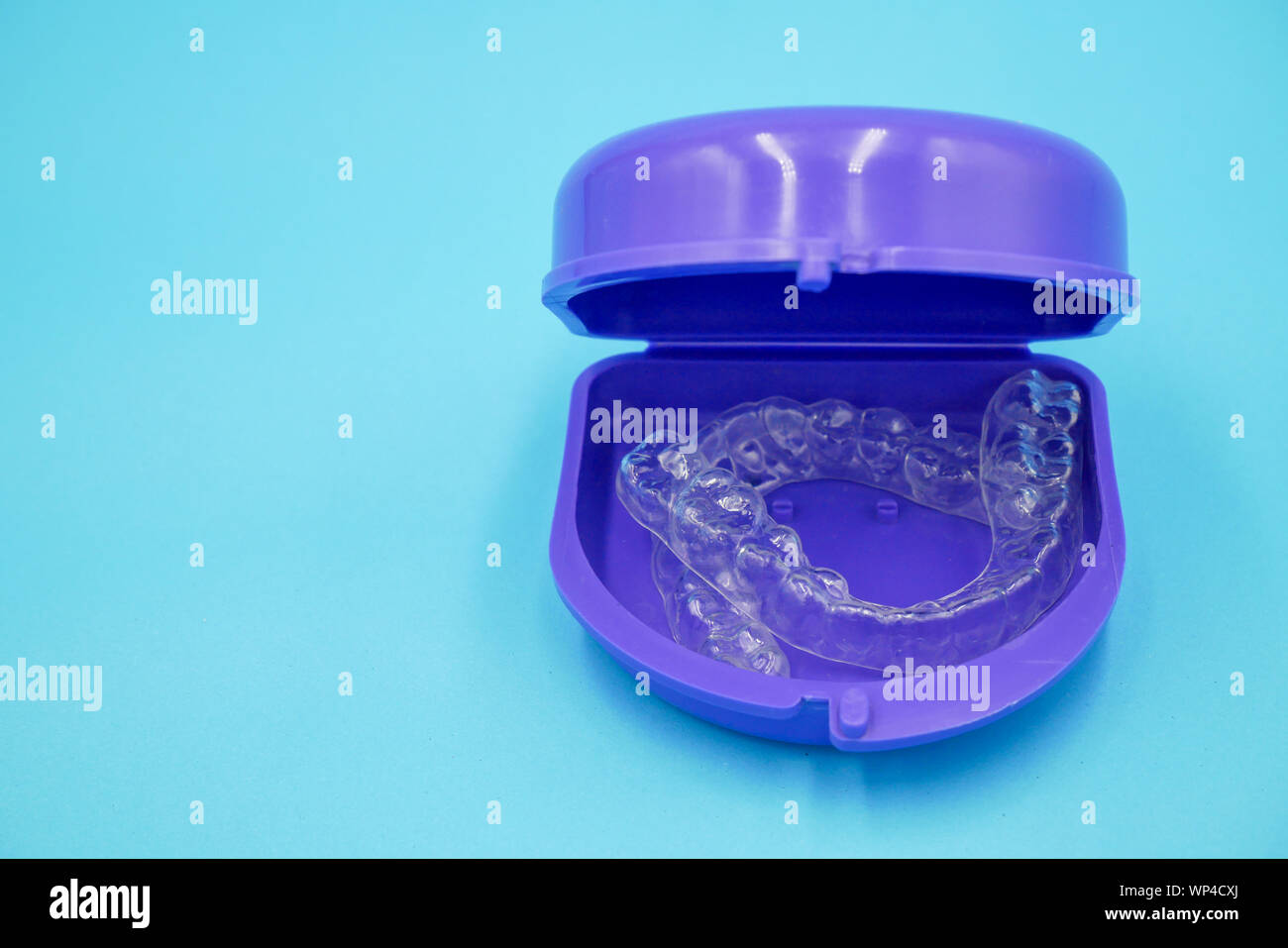 clear plastic retainer teeth in the box set isolated on blue sky ...