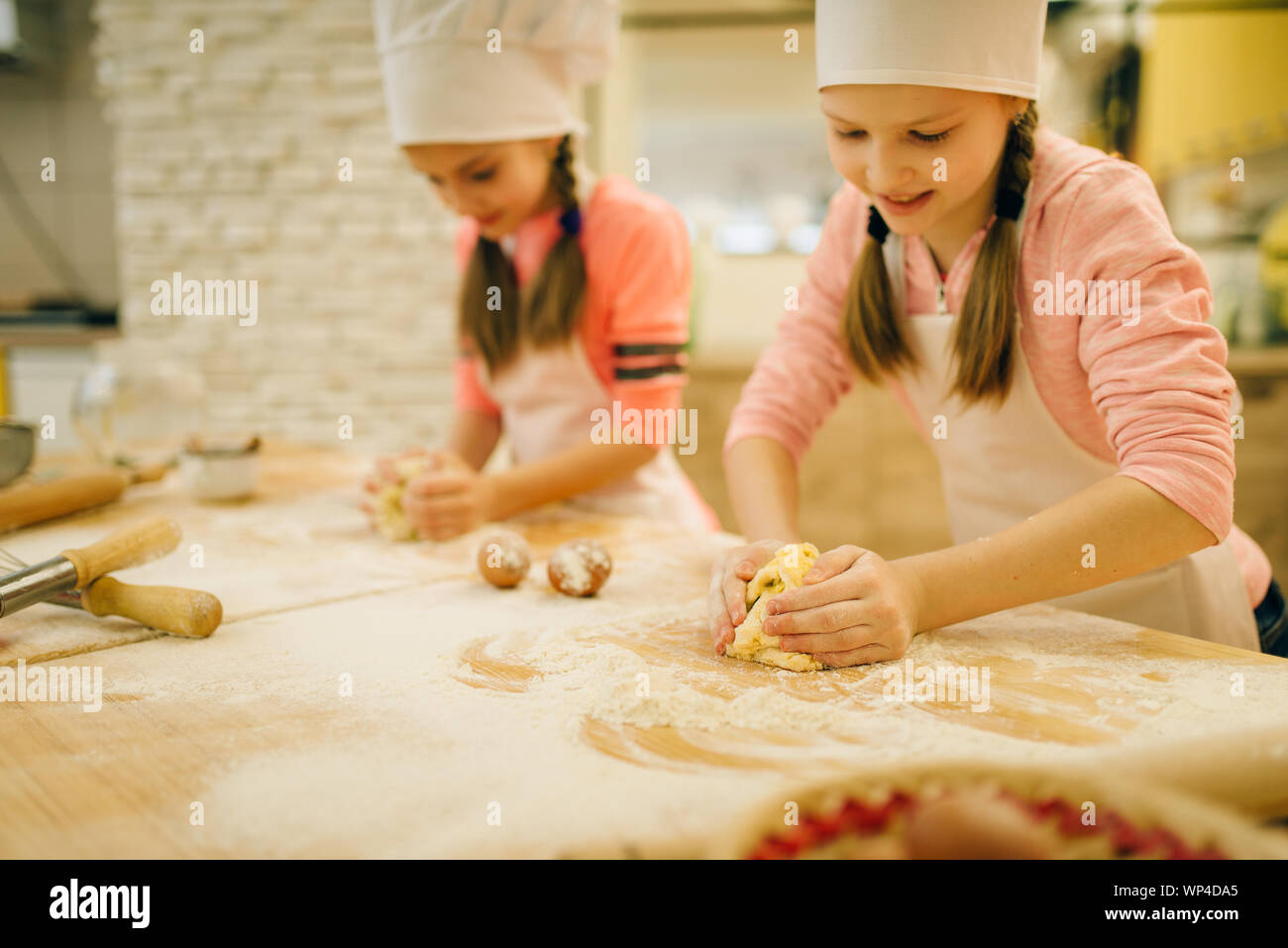 Little girls chefs crumple the dough, funny bakers Stock Photo - Alamy