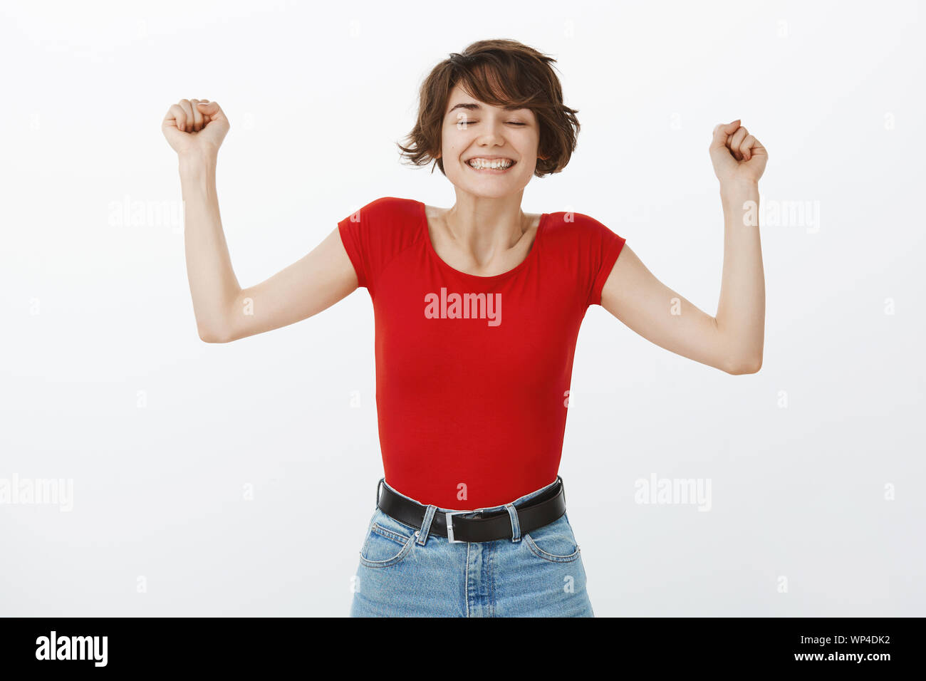 Yes I did it finally. Satisfied cute woman raising hands up victory ...