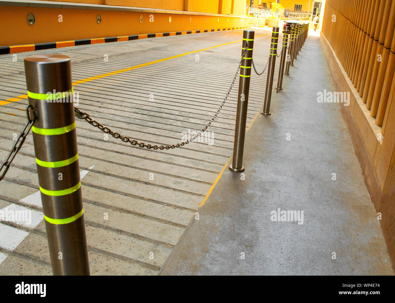 Metal fence with chain along pedestrian walkway. Balustrade separates ...