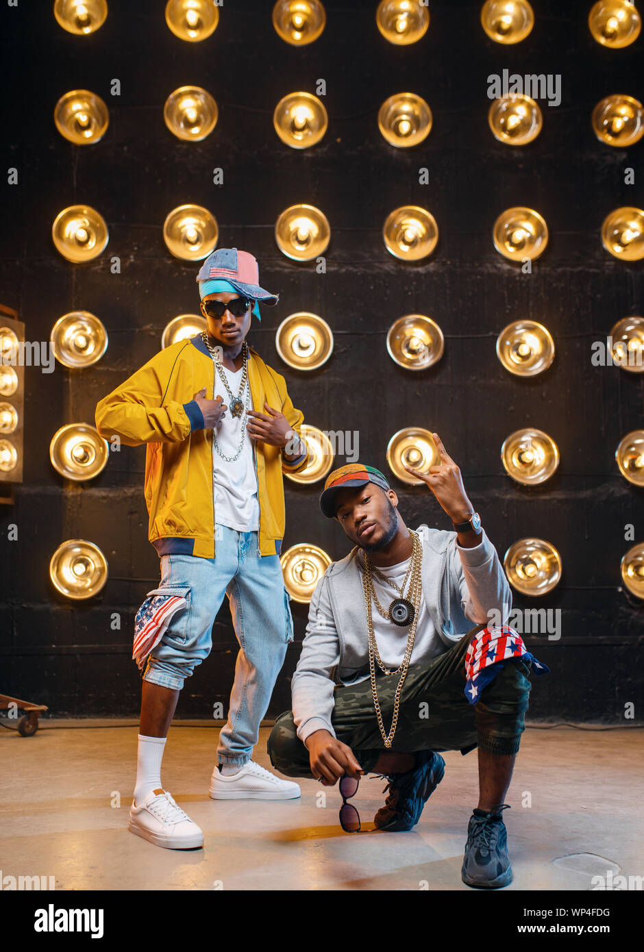 Rappers in caps dance on stage with spotlights Stock Photo - Alamy