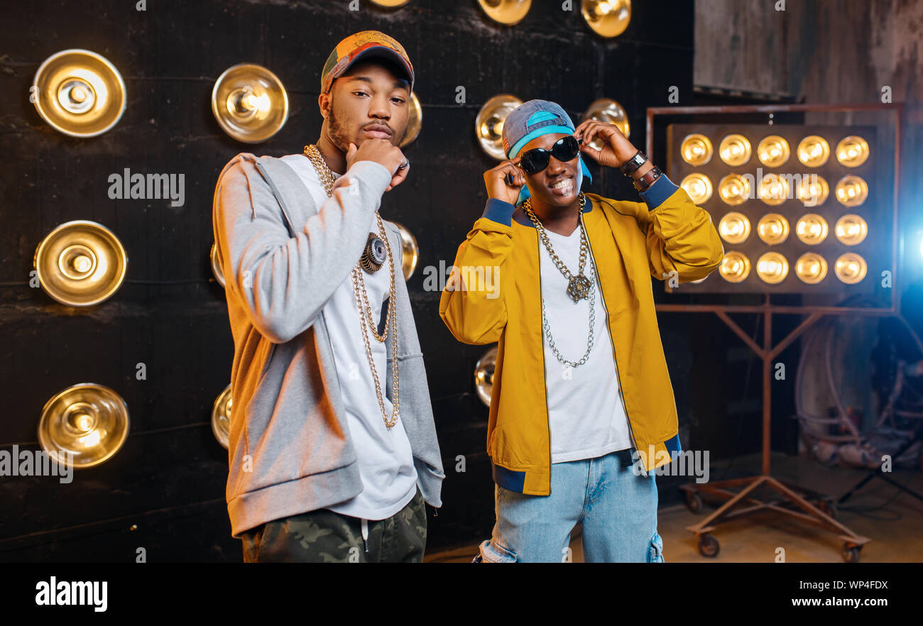 Two black rappers in caps on stage with spotlights Stock Photo - Alamy