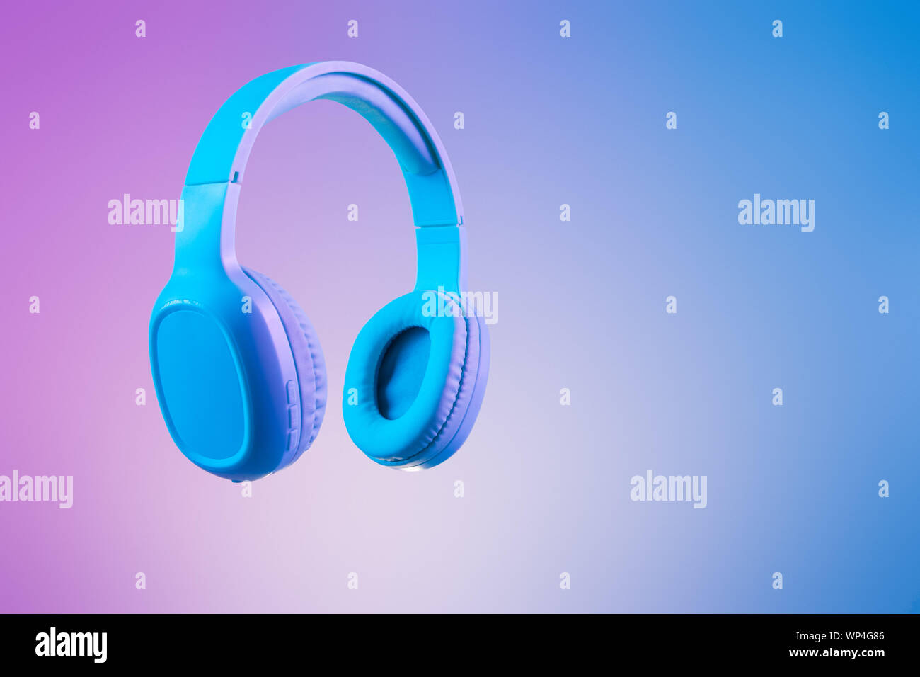 Stylish blue headphones on multi coloured / duo tone background ...