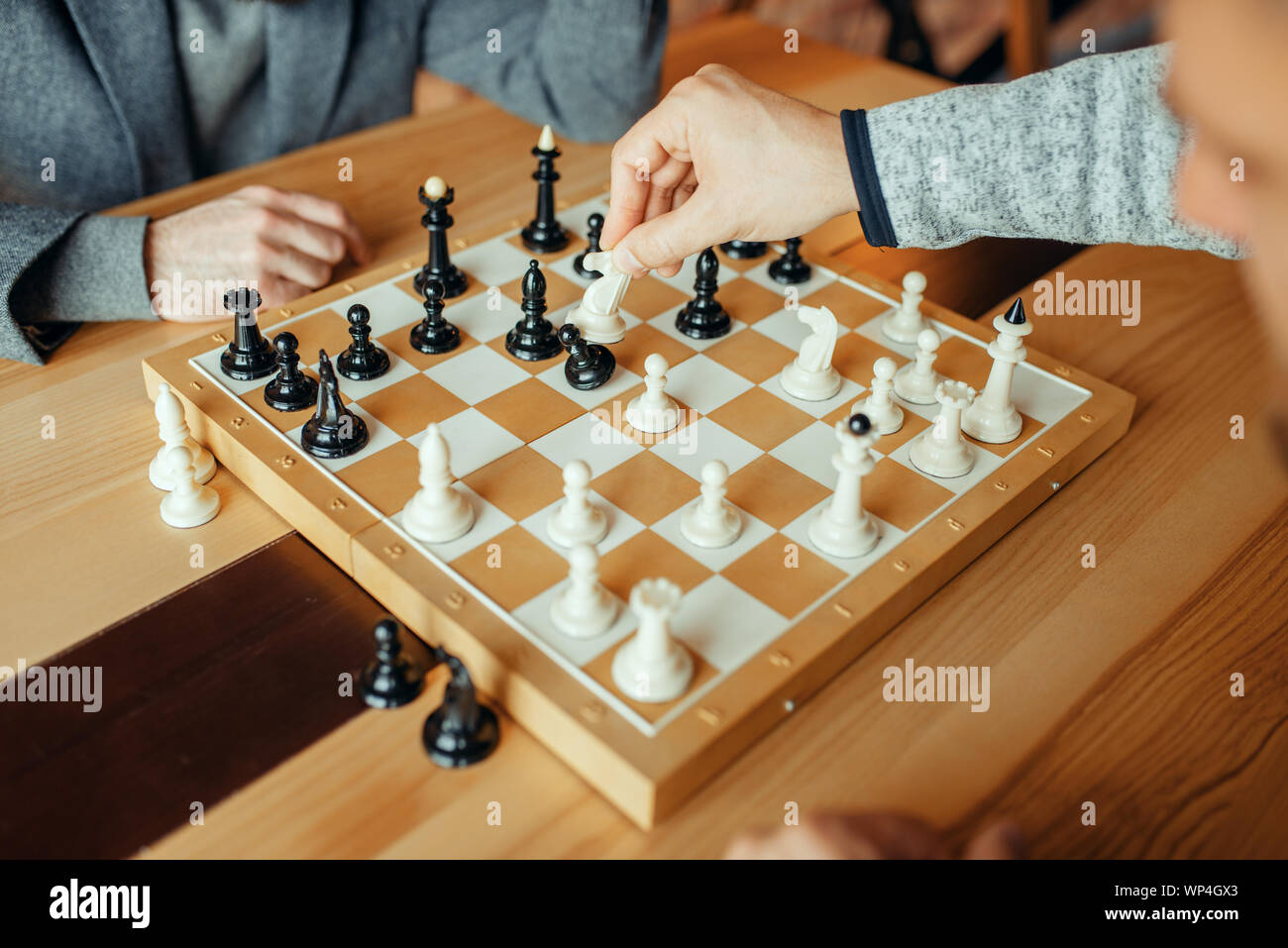 Male chess players, white knight takes pawn Stock Photo - Alamy